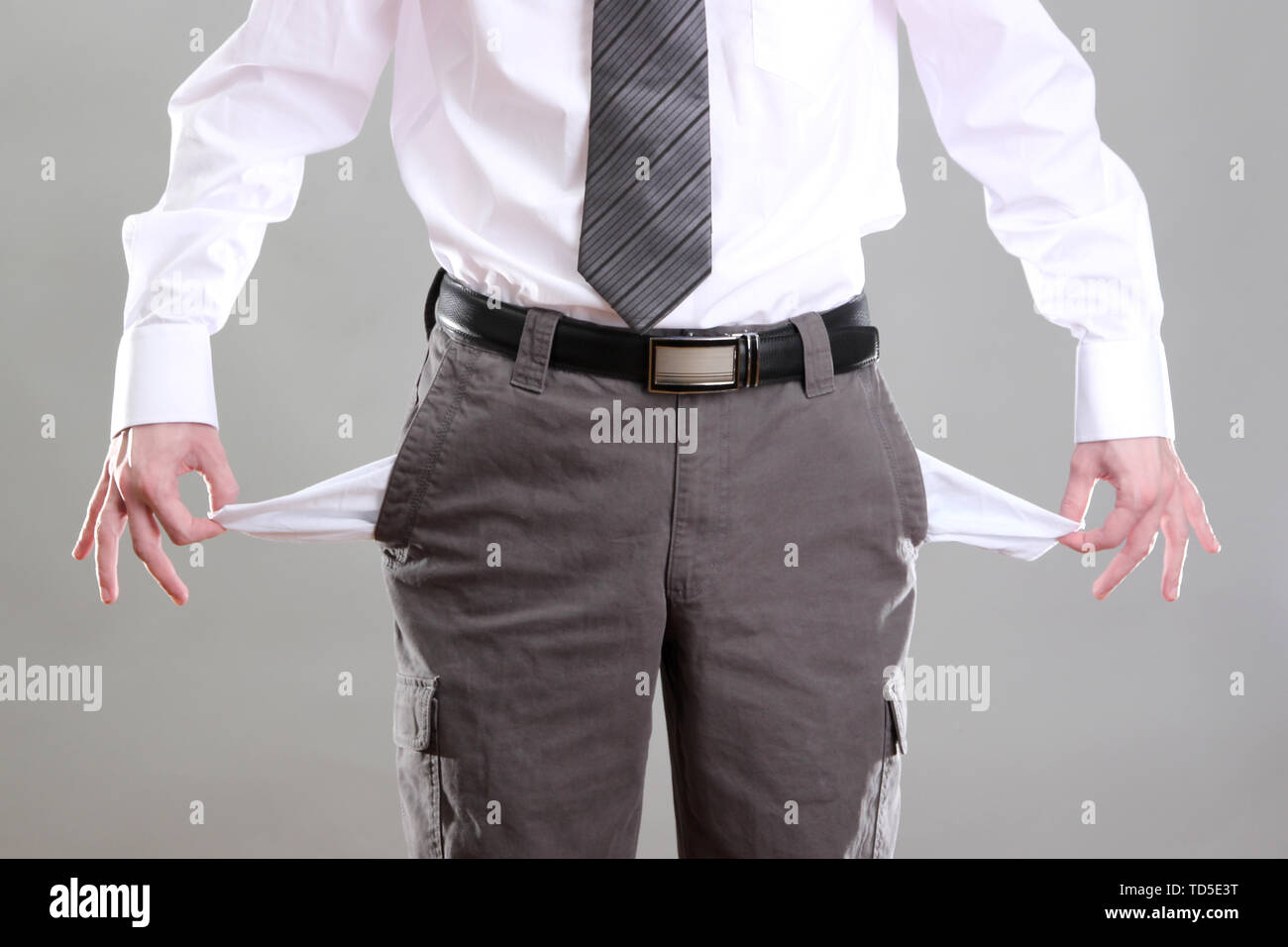 Business man showing his empty pockets, on grey background Stock Photo ...