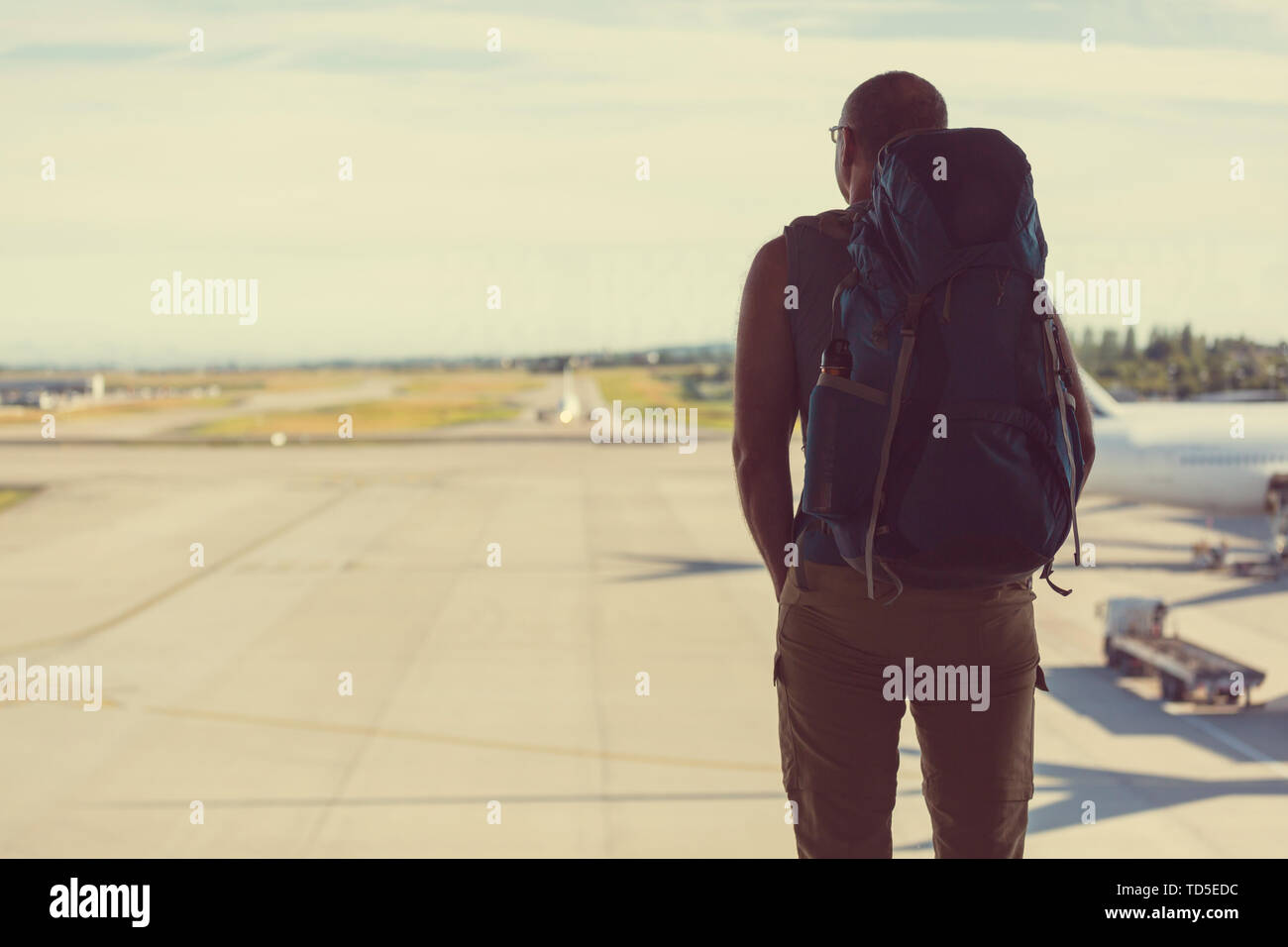 Backpacker near window in airport Stock Photo - Alamy