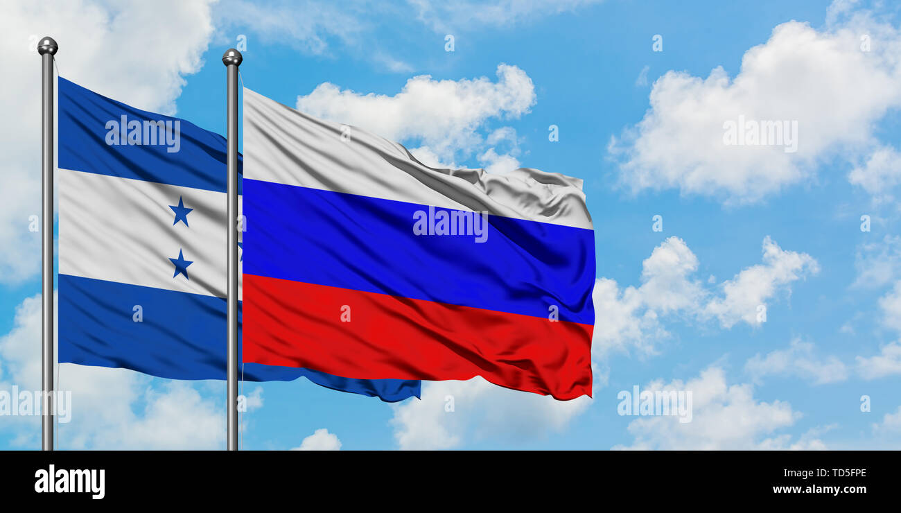 Honduras and Russia flag waving in the wind against white cloudy blue ...