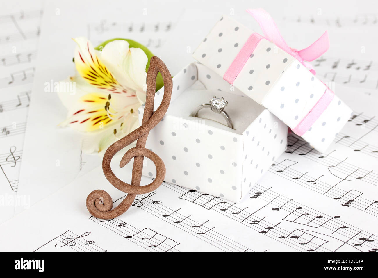 Treble clef, flower and box holding wedding ring on musical background ...