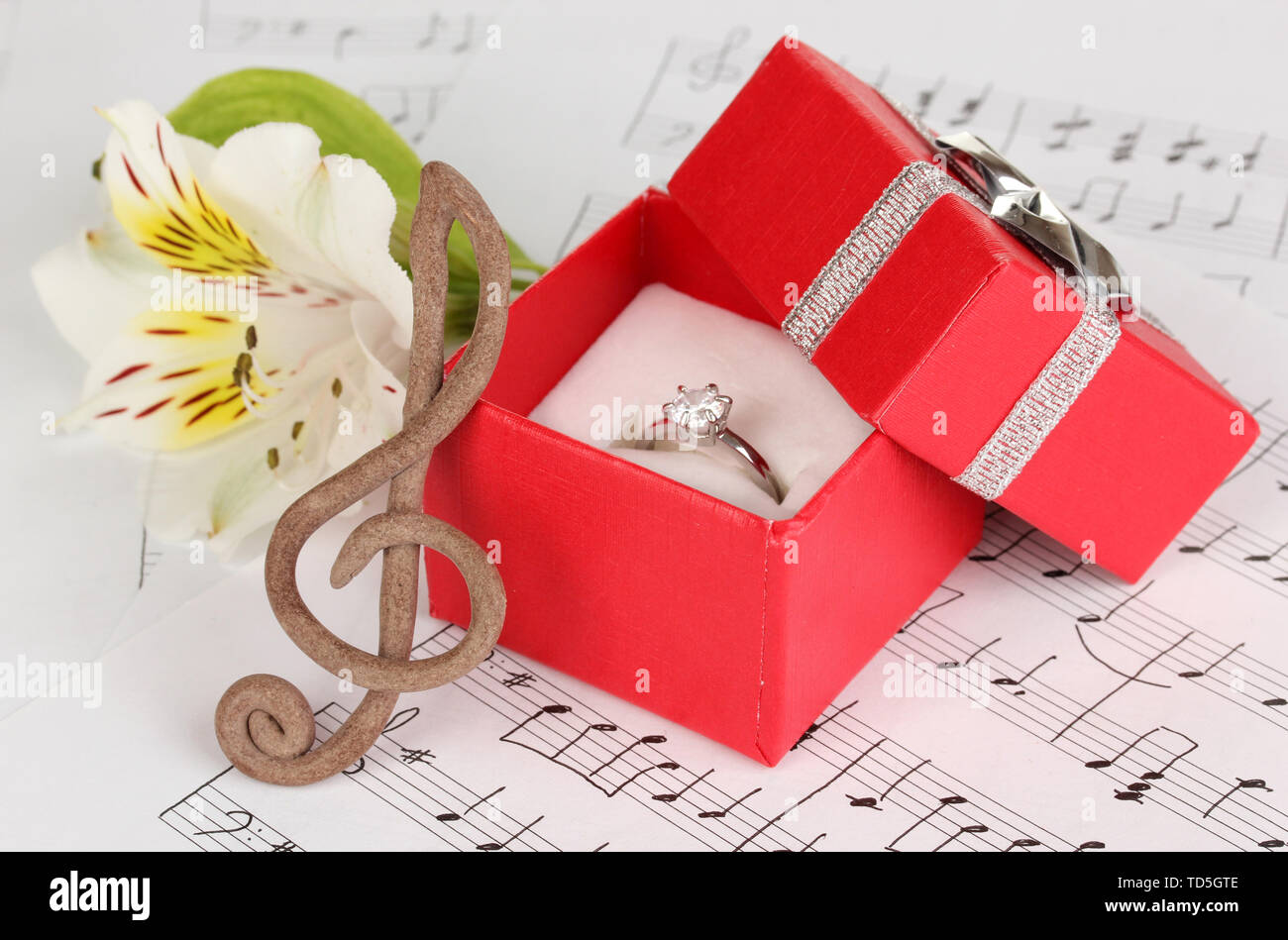 Treble clef, flower and box holding wedding ring on musical background ...