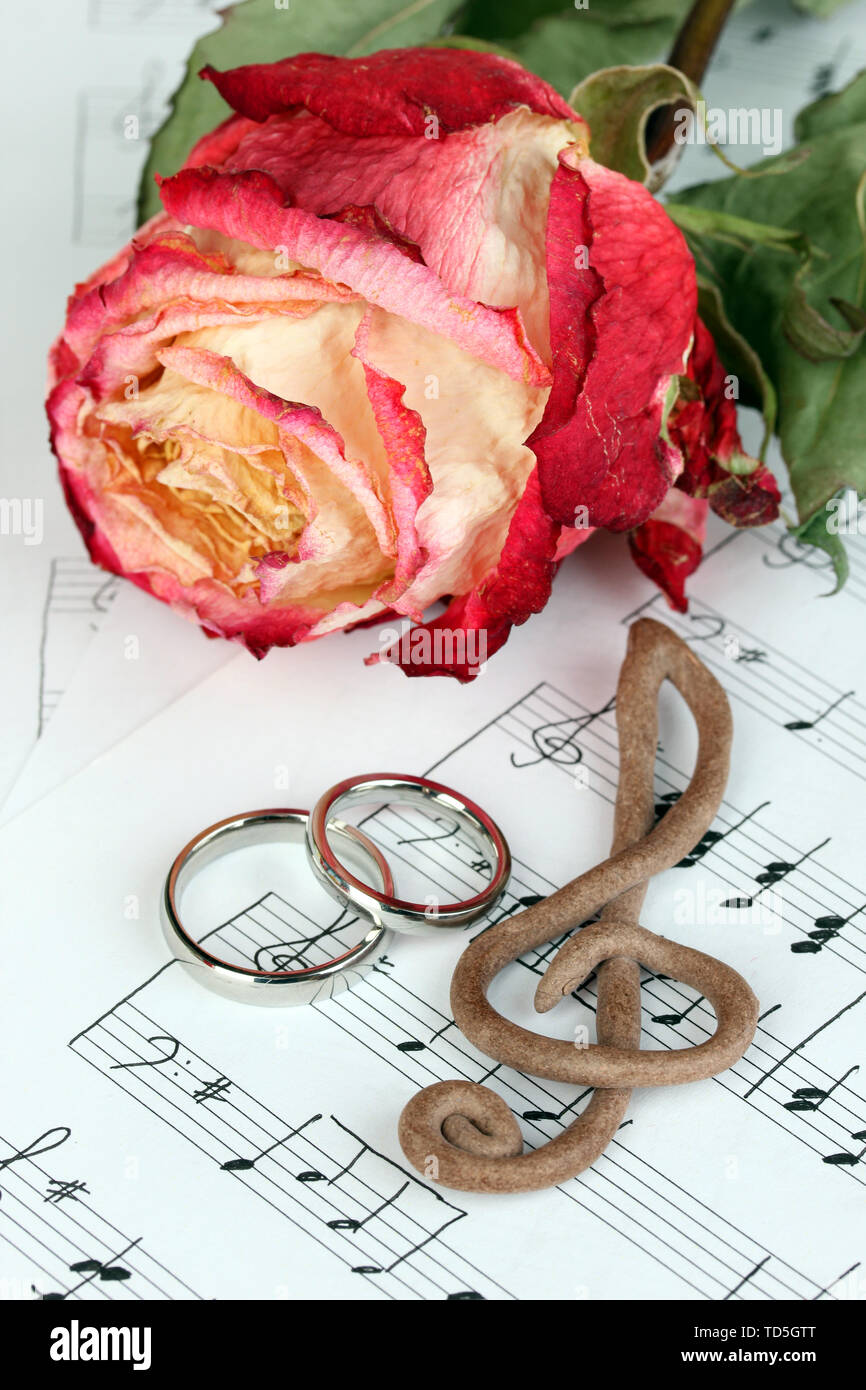 Treble clef, roses and wedding rings on musical background Stock Photo ...