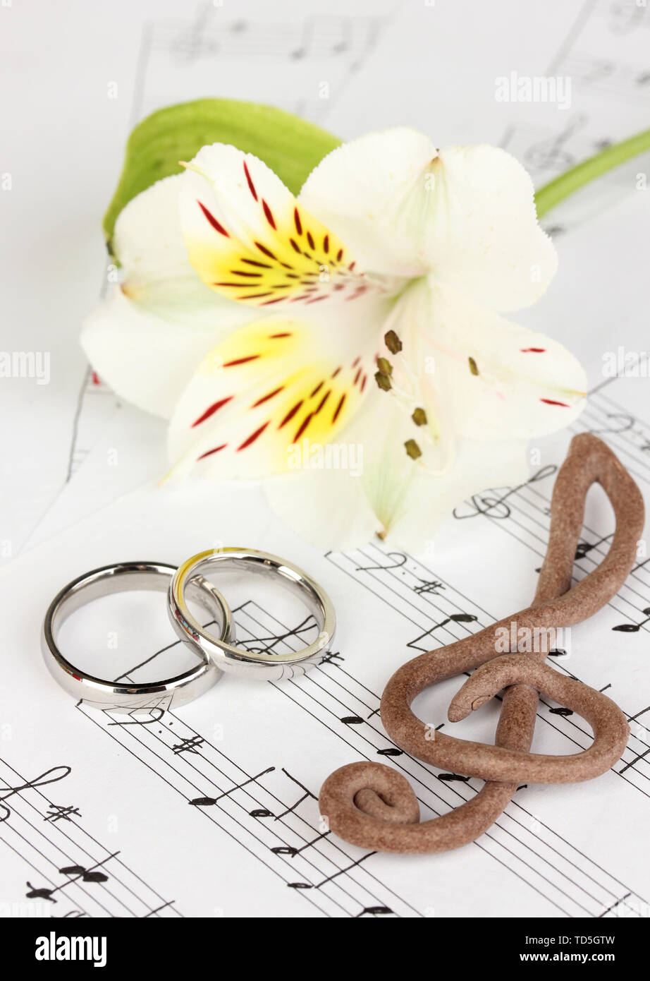 Treble clef, flower and wedding rings on musical background Stock Photo ...