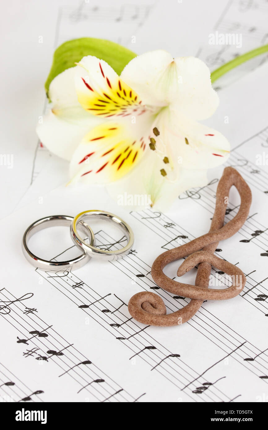Treble clef, flower and wedding rings on musical background Stock Photo ...