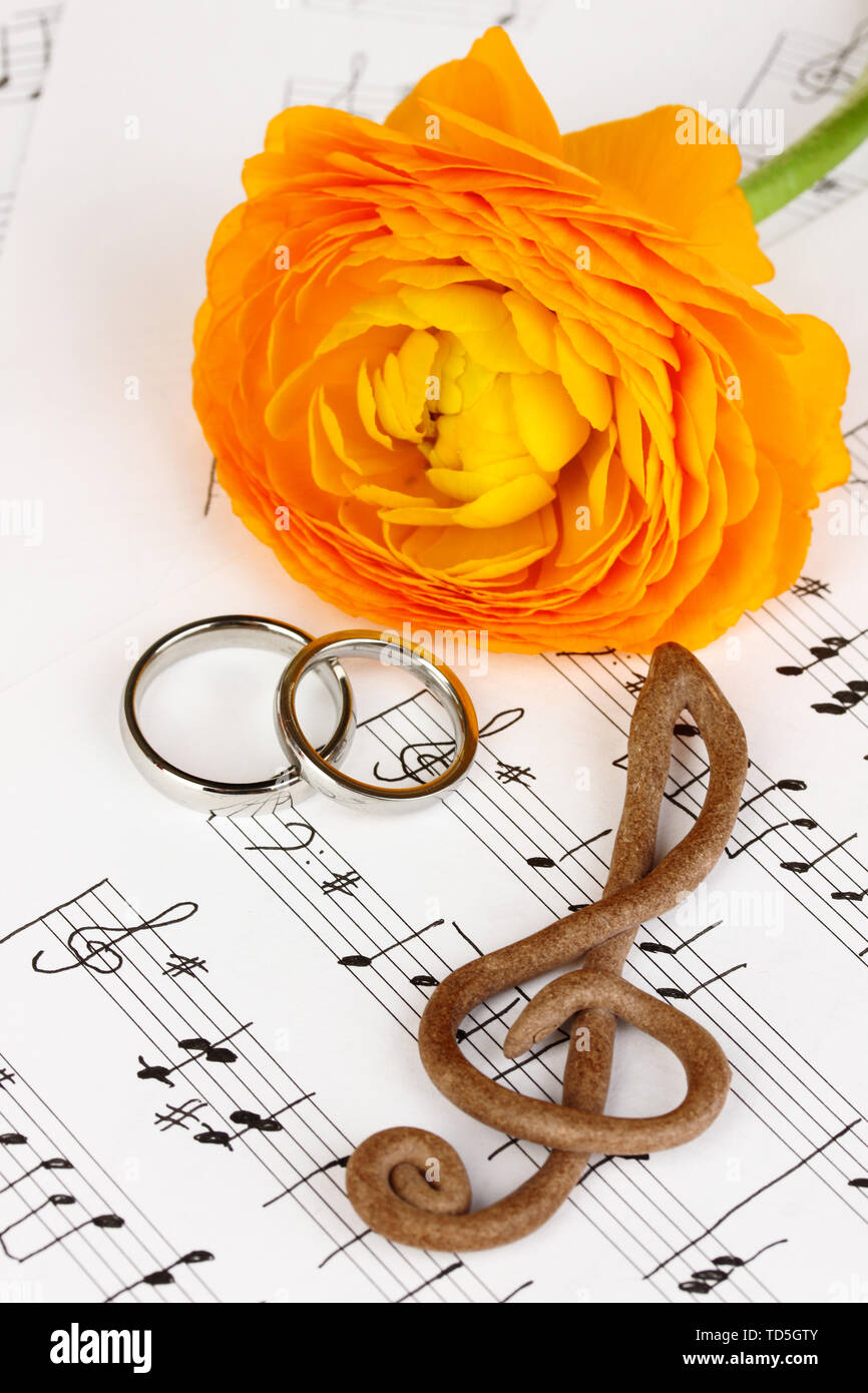 Treble clef, flower and wedding rings on musical background Stock Photo ...