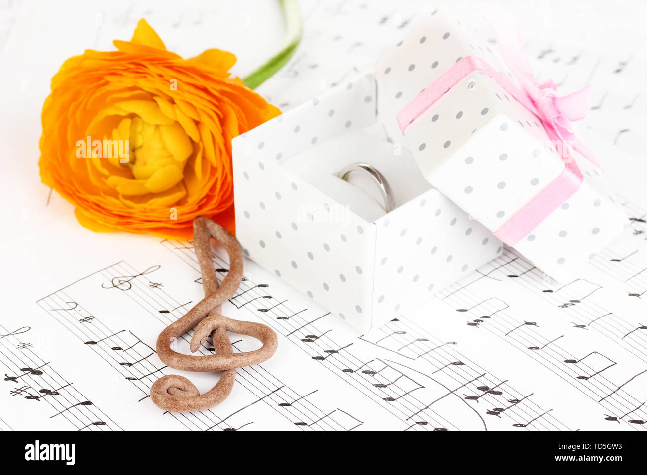 Treble clef, flower and box holding wedding ring on musical background ...