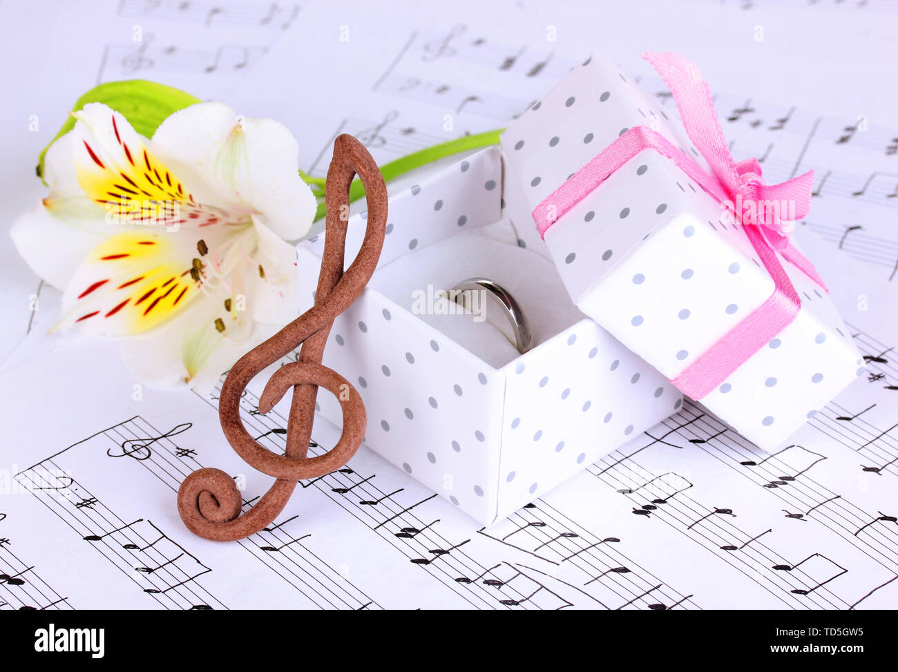 Treble clef, flower and box holding wedding ring on musical background ...