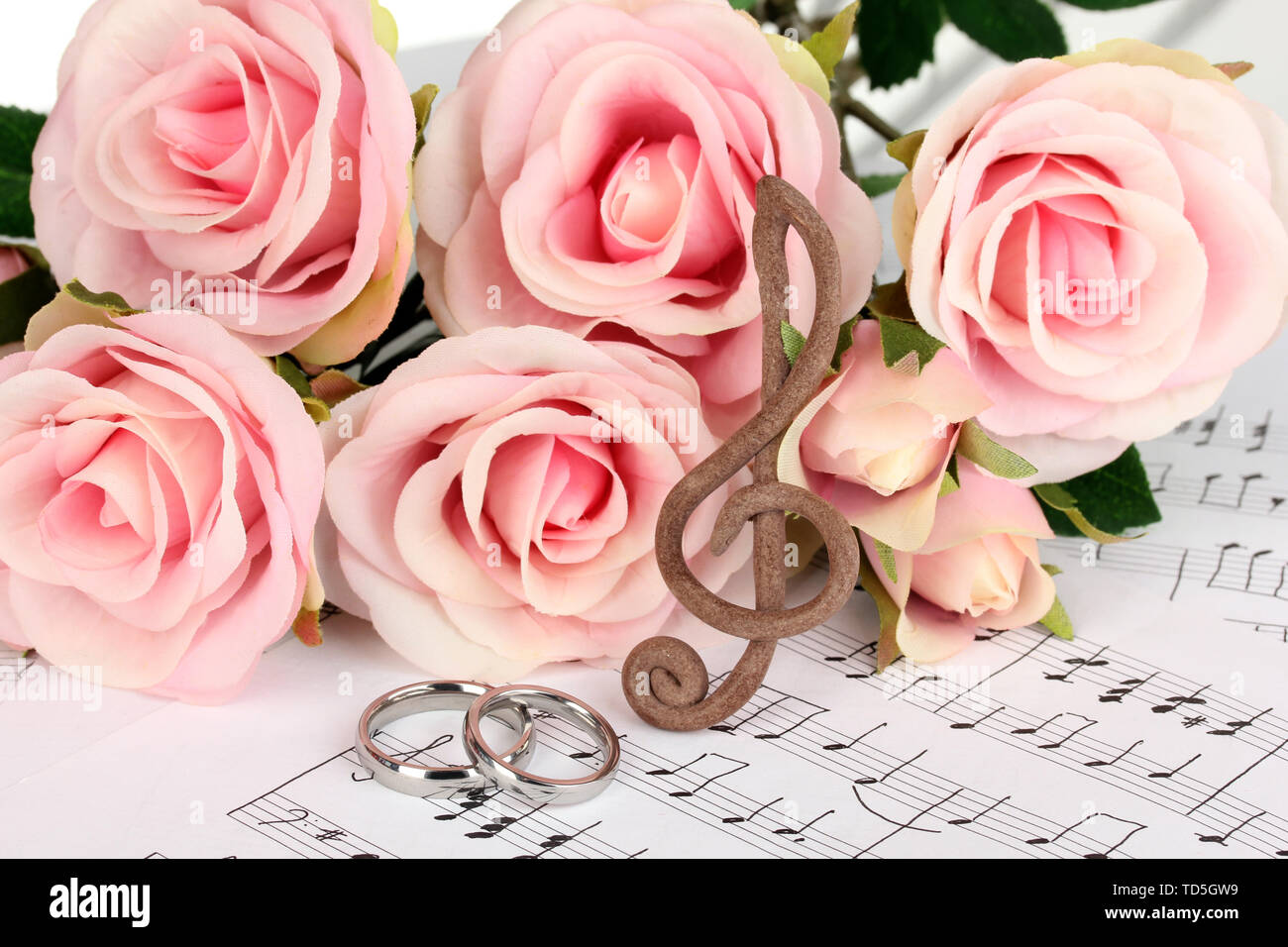 Treble clef, roses and wedding rings on musical background Stock Photo ...