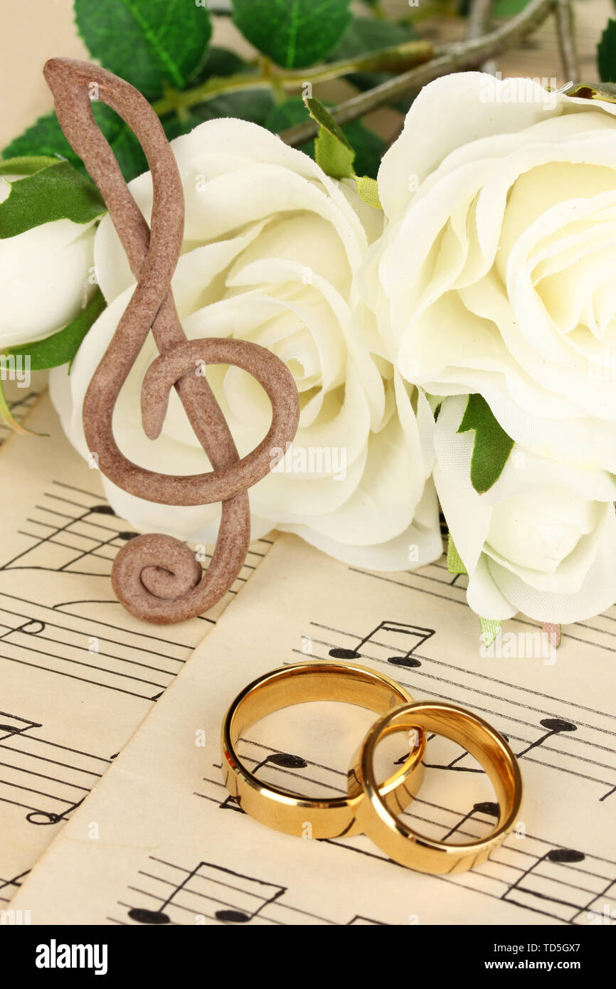Treble clef, roses and wedding rings on musical background Stock Photo ...