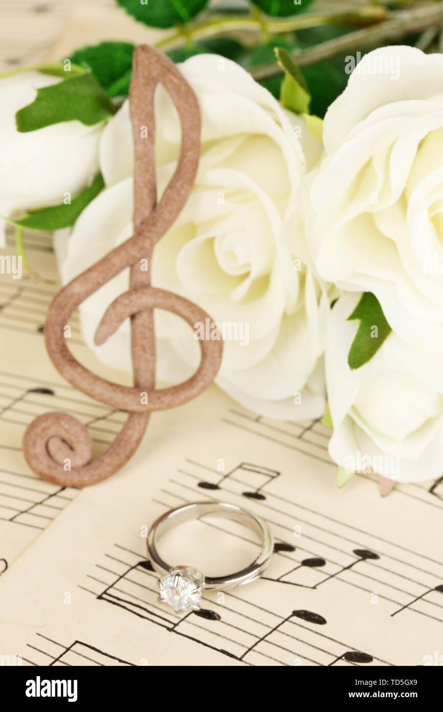 Treble clef, roses and wedding ring on musical background Stock Photo ...