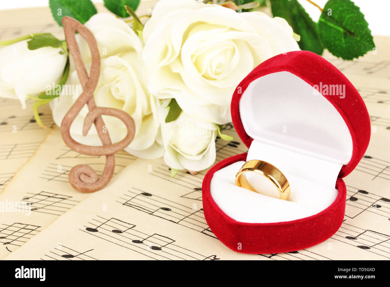 Treble clef, roses and box holding wedding ring on musical background ...