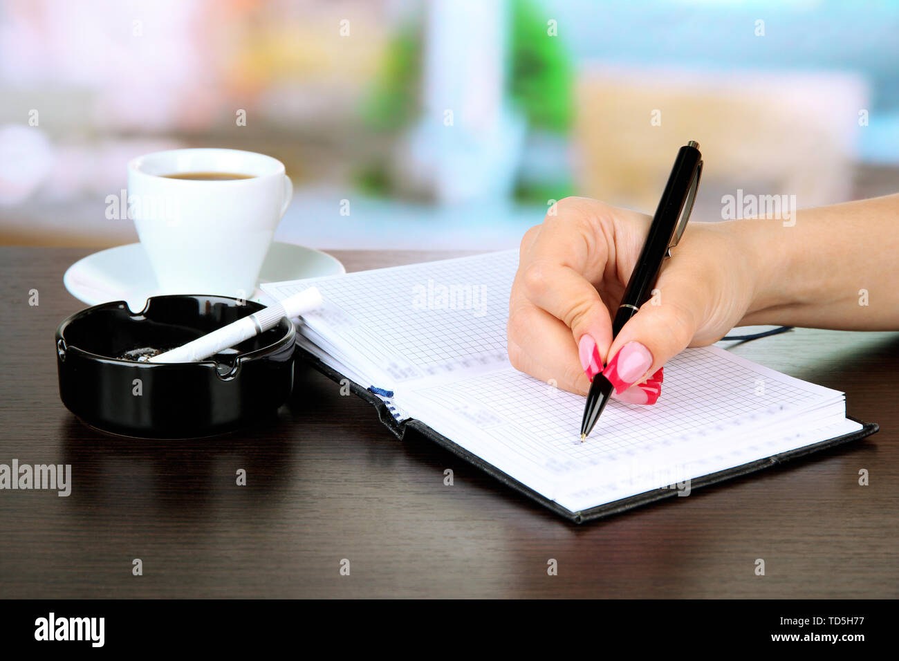 Hand signing in notebook, on bright background Stock Photo - Alamy
