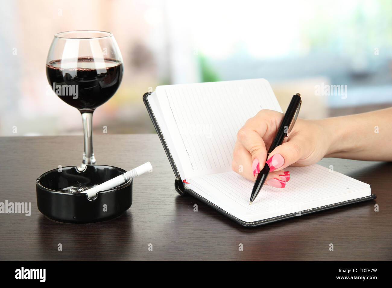 Hand signing in notebook, on bright background Stock Photo - Alamy