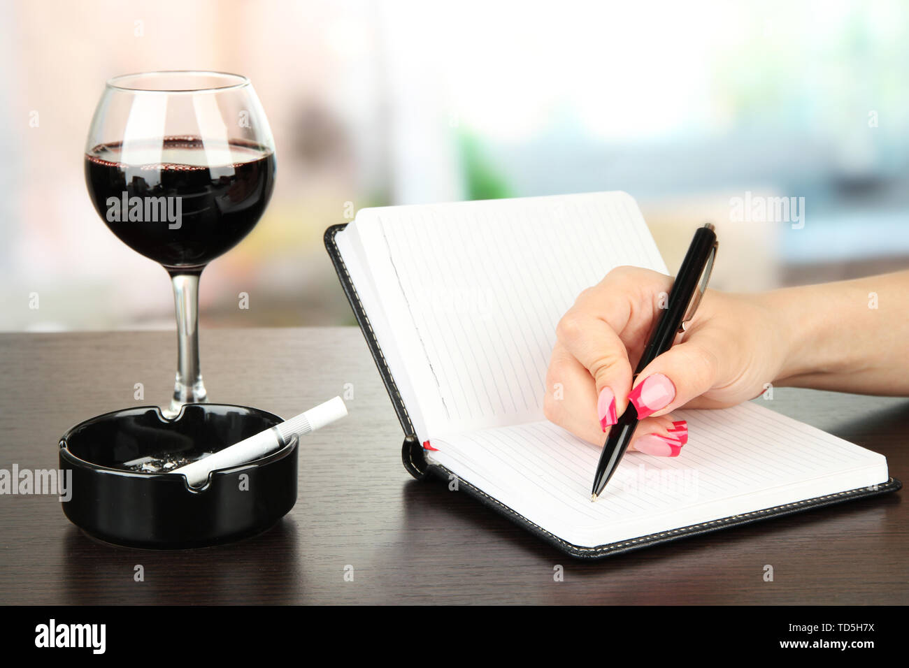 Hand signing in notebook, on bright background Stock Photo - Alamy