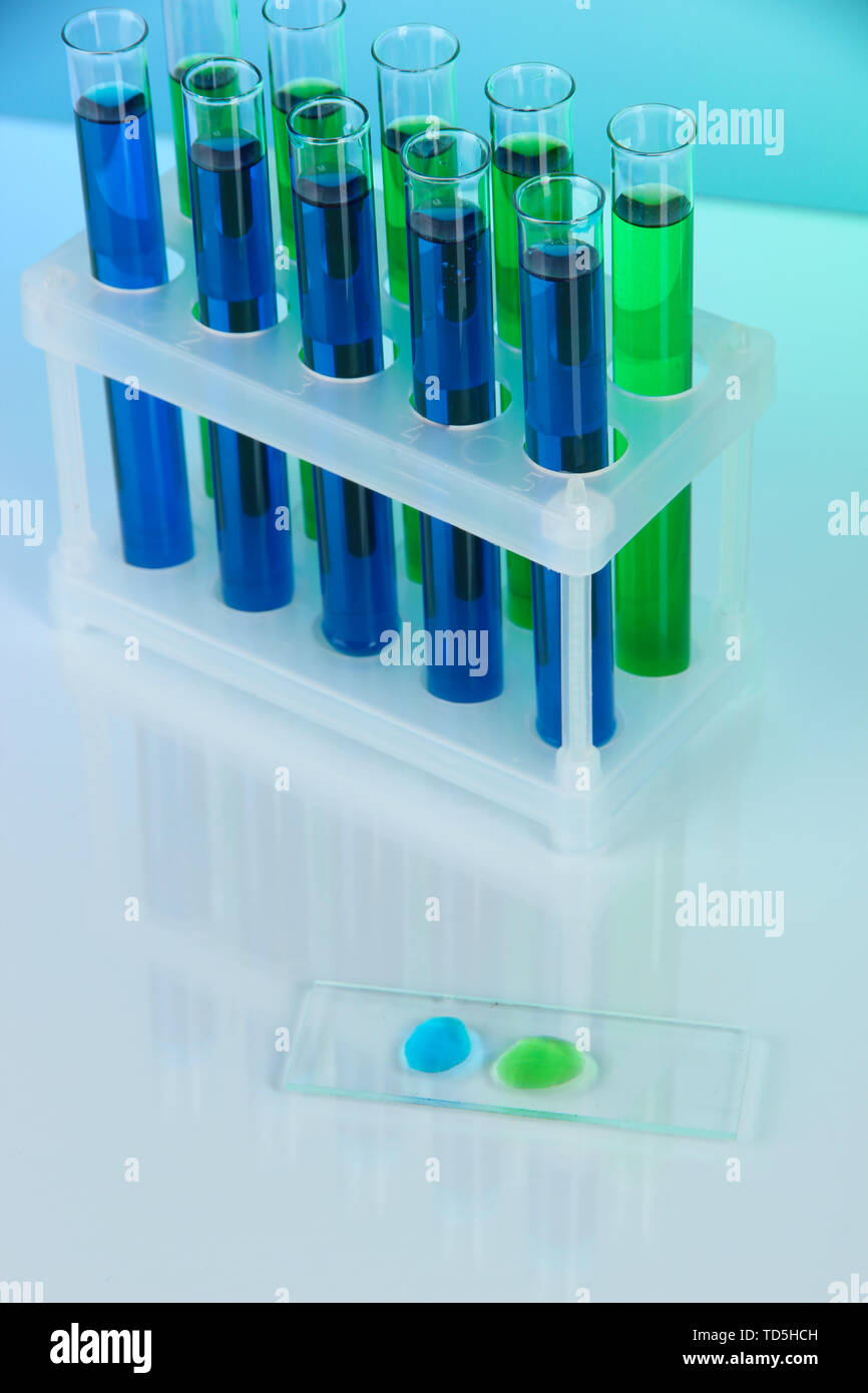 Identical test tubes on blue background Stock Photo - Alamy