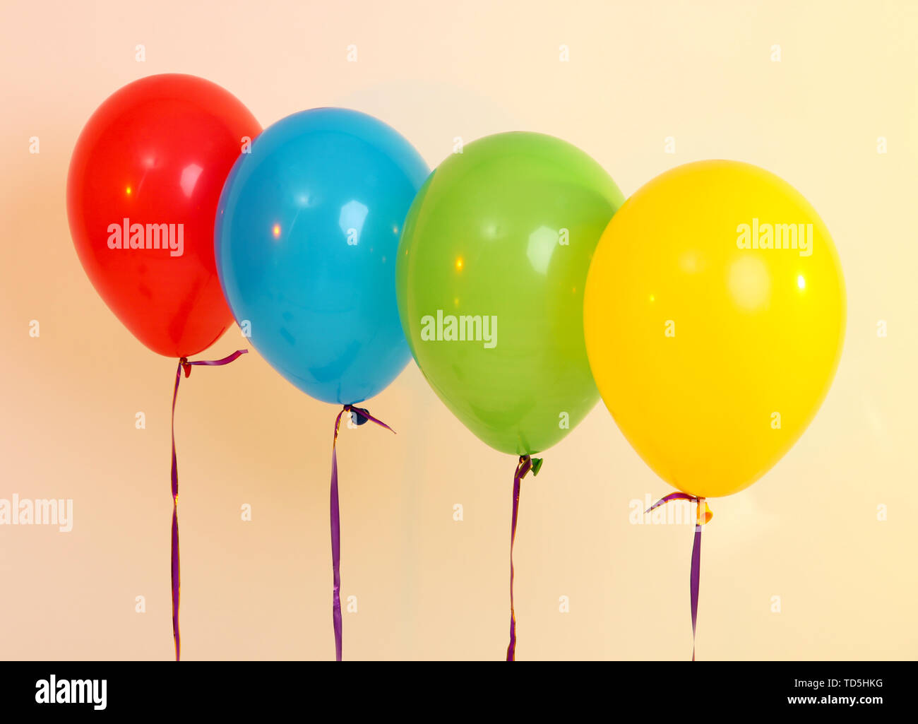 Four bright balloons on light background Stock Photo - Alamy