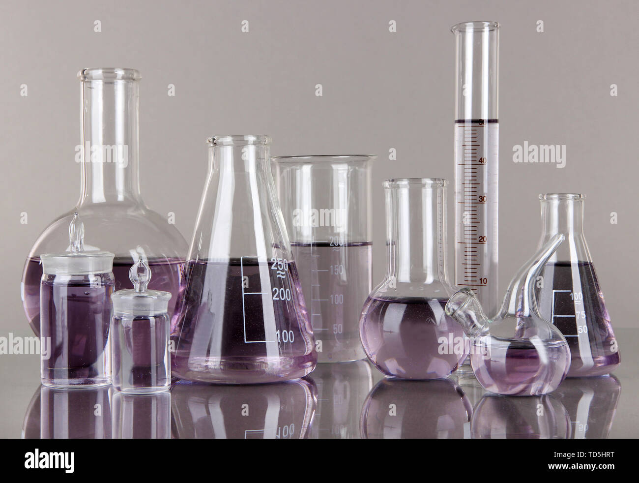 Test-tubes with light purple liquid on gray background Stock Photo - Alamy
