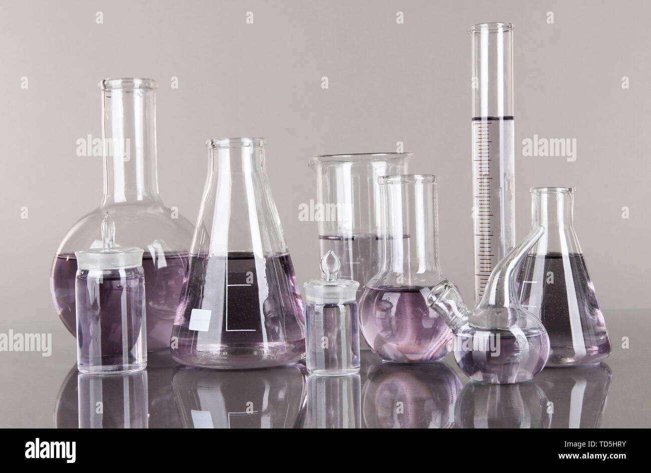 Test-tubes with light purple liquid on gray background Stock Photo - Alamy