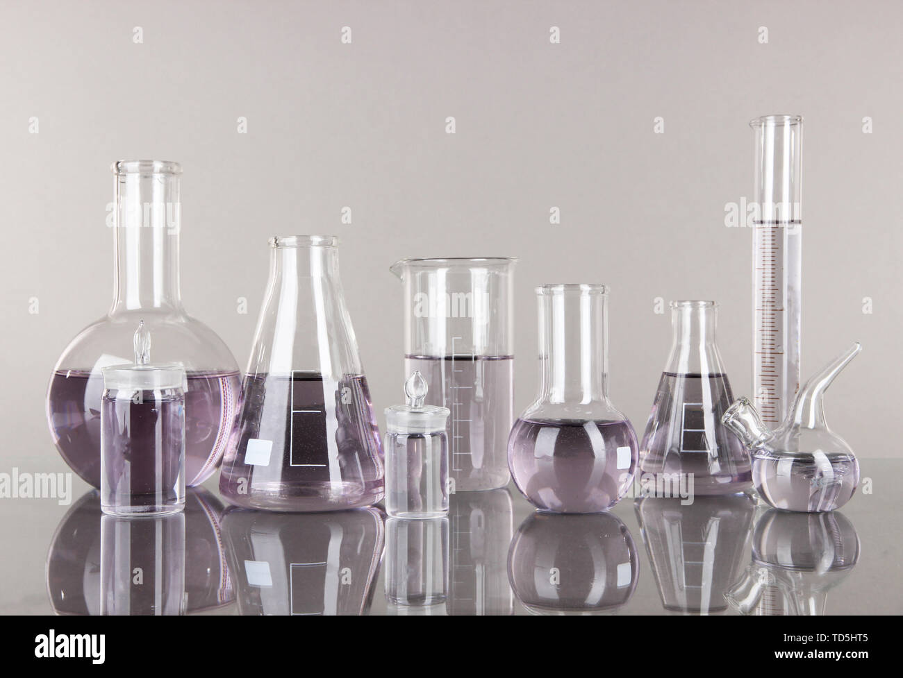 Test-tubes with light purple liquid on gray background Stock Photo - Alamy