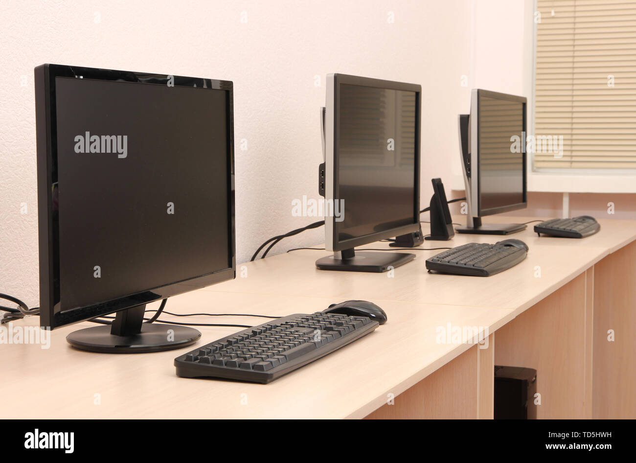 Computers on tables in room Stock Photo - Alamy