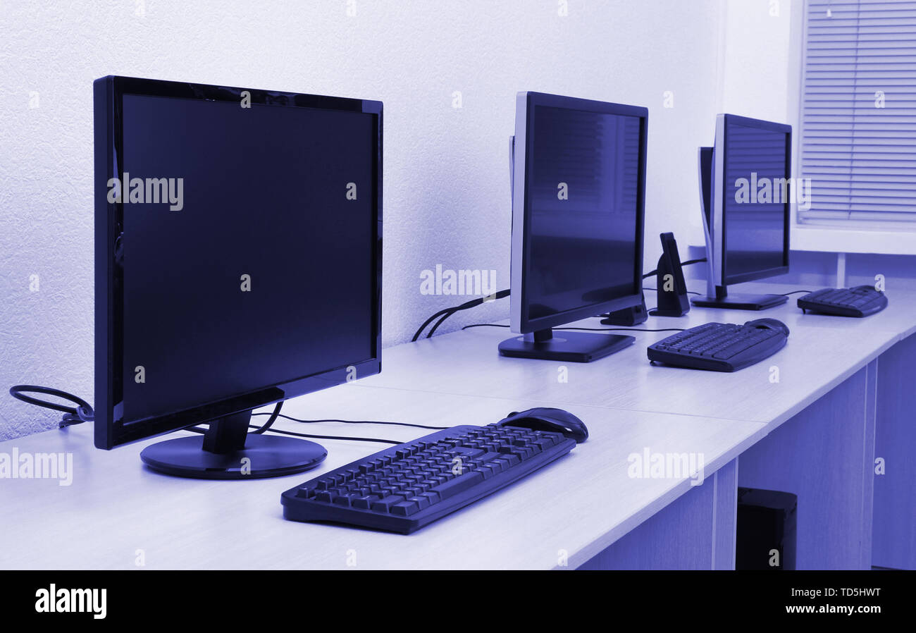 Computers on tables in room Stock Photo - Alamy