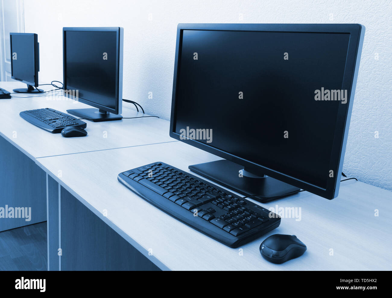Computers on tables in room Stock Photo - Alamy