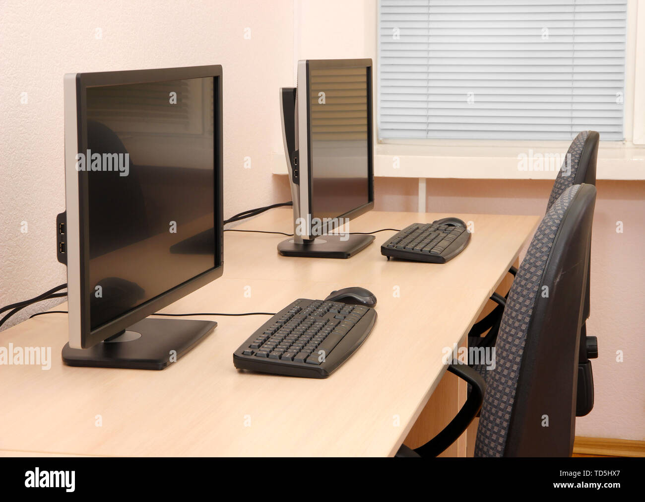 Computers on tables in room Stock Photo - Alamy