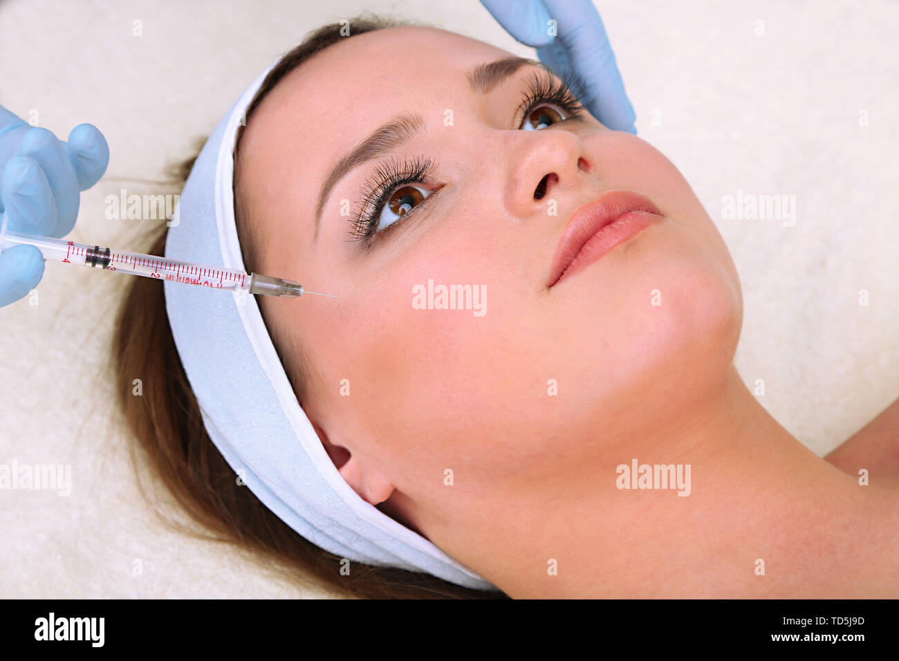 Young woman receiving plastic surgery injection on her face close up ...