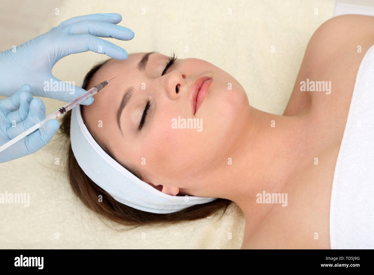 Young woman receiving plastic surgery injection on her face close up ...