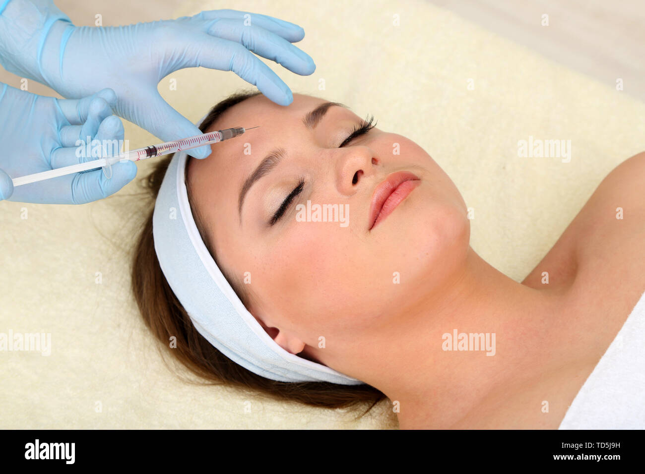 Young woman receiving plastic surgery injection on her face close up ...