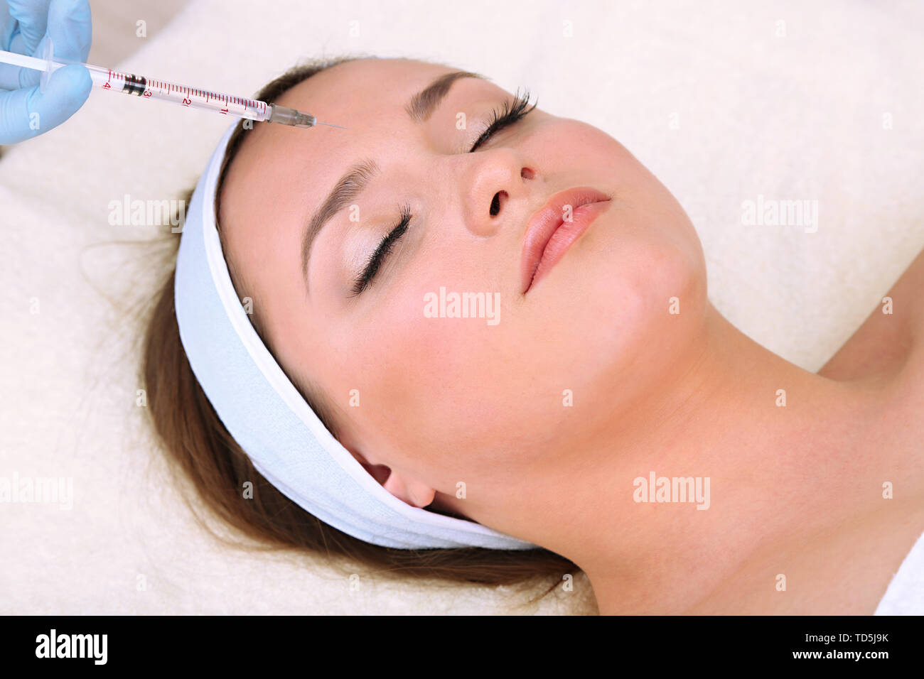 Young woman receiving plastic surgery injection on her face close up ...