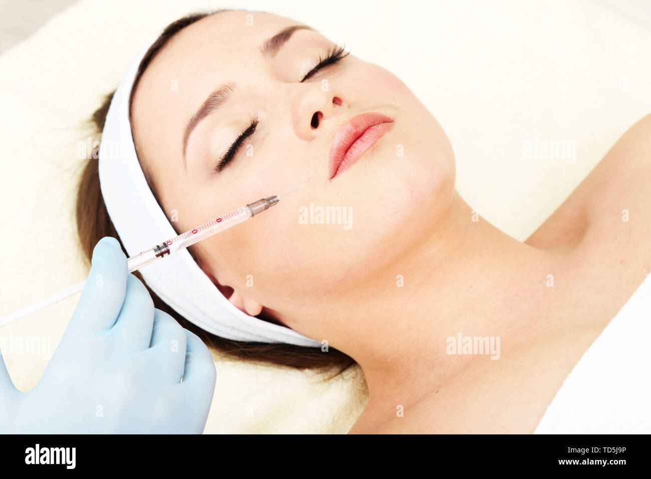 Young woman receiving plastic surgery injection on her face close up ...