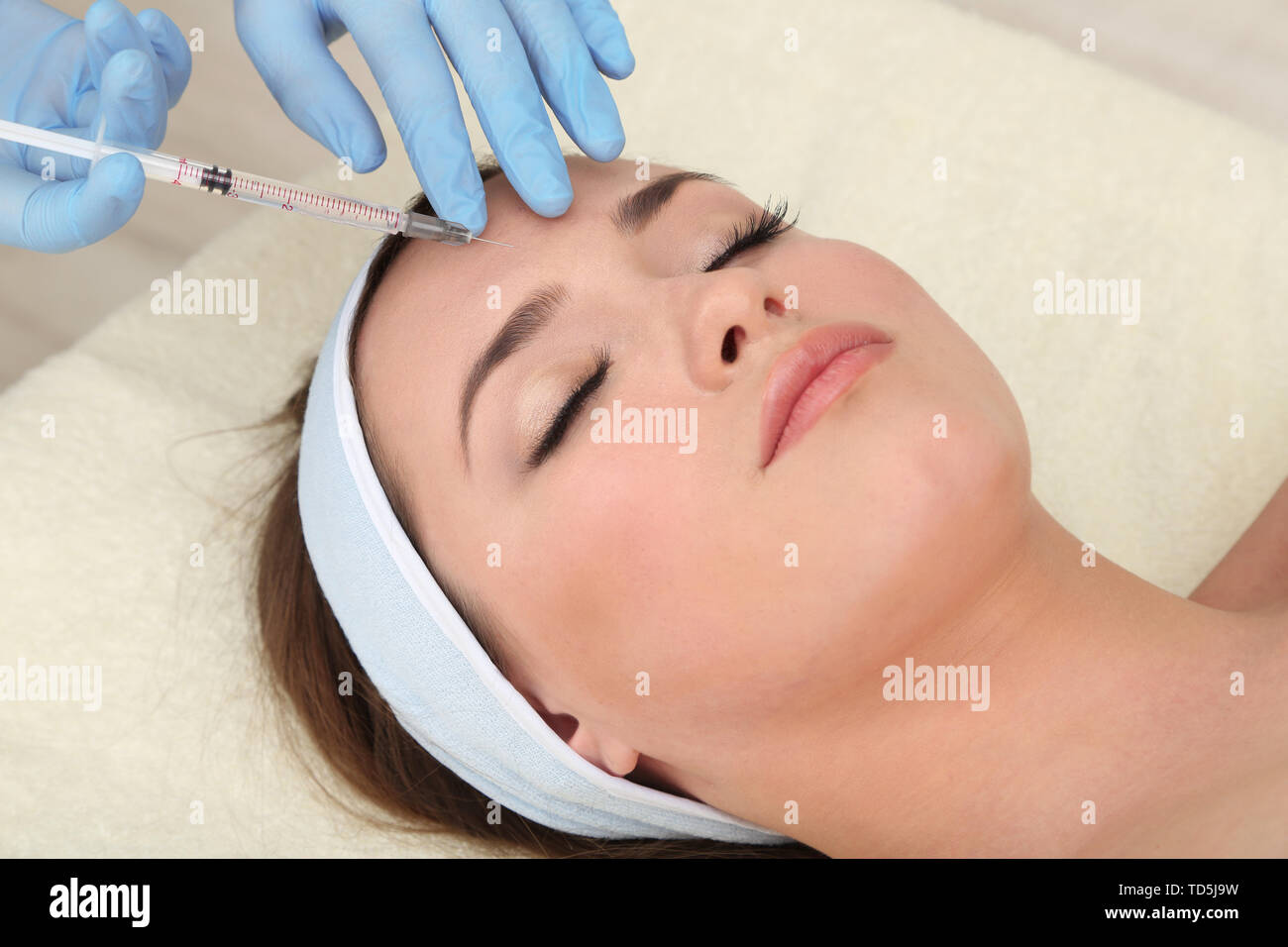 Young woman receiving plastic surgery injection on her face close up ...