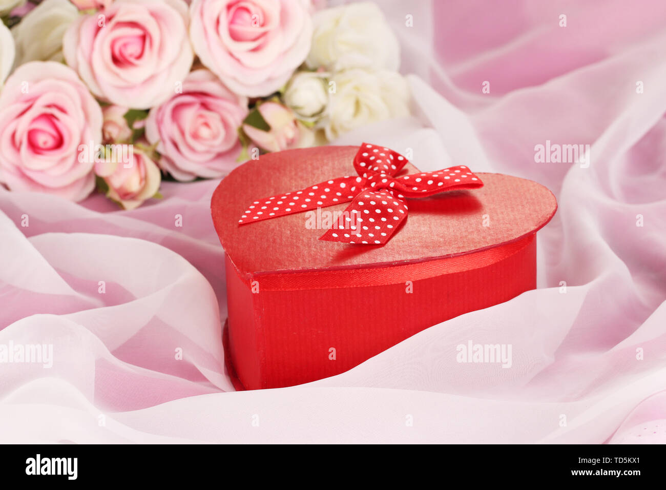 Beautiful gift on flowers background Stock Photo - Alamy
