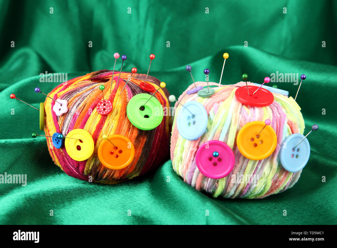 Colorful buttons and multicolor wool balls, on color fabric background ...