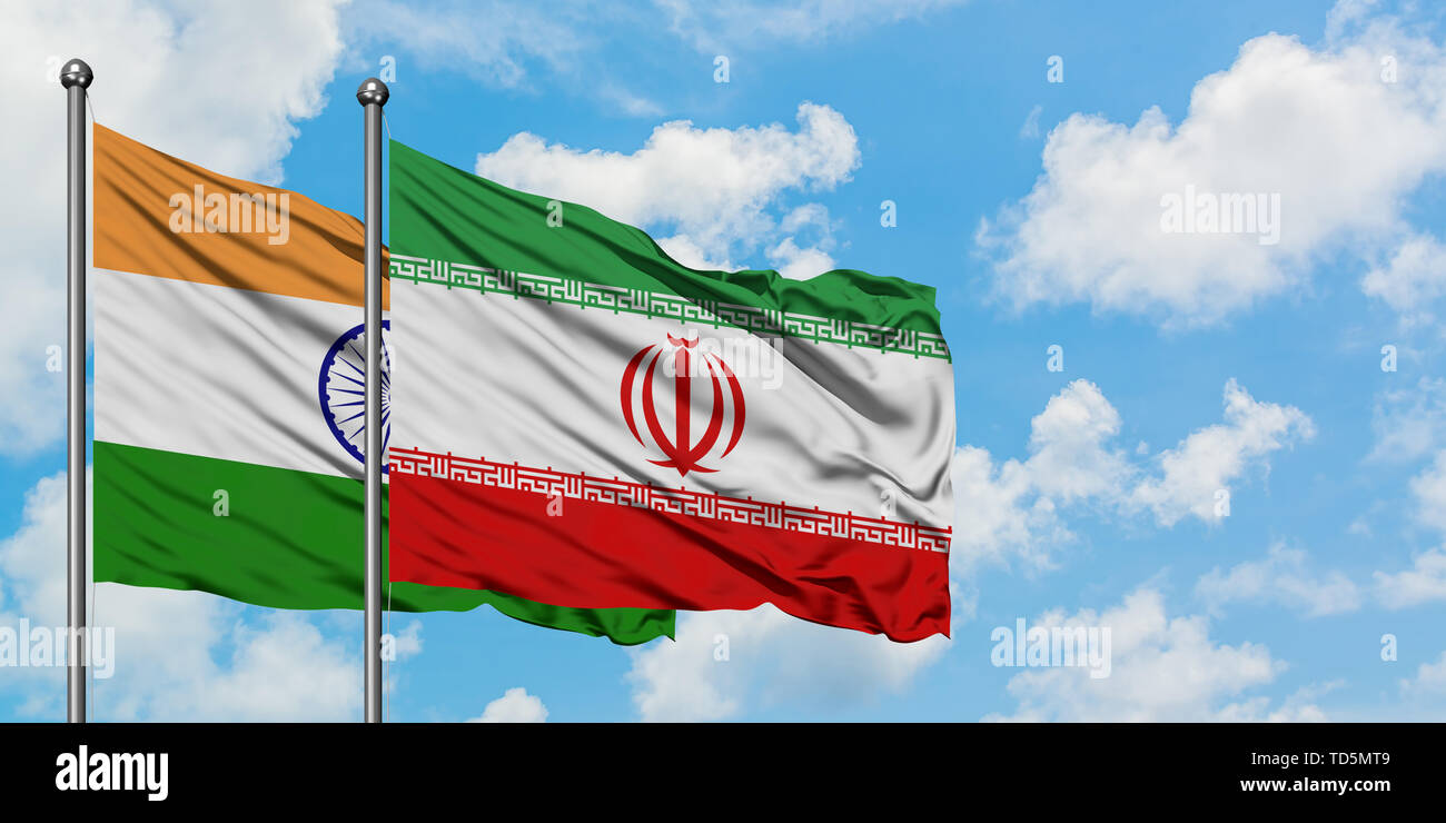 India and Iran flag waving in the wind against white cloudy blue sky ...