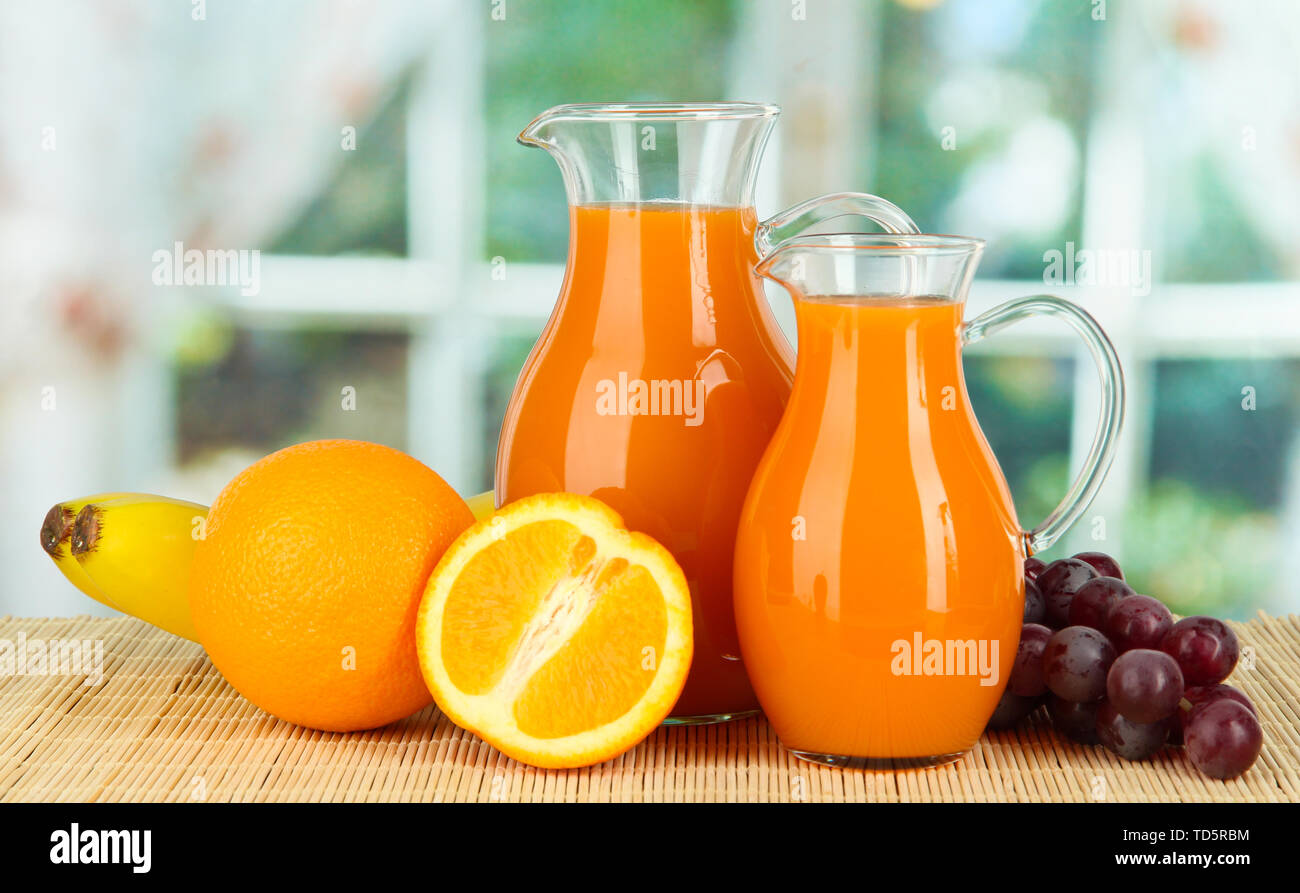 Orange juice in pitchers on table in room Stock Photo - Alamy