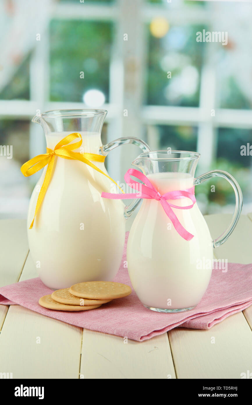 Pitchers of milk on table in room Stock Photo - Alamy