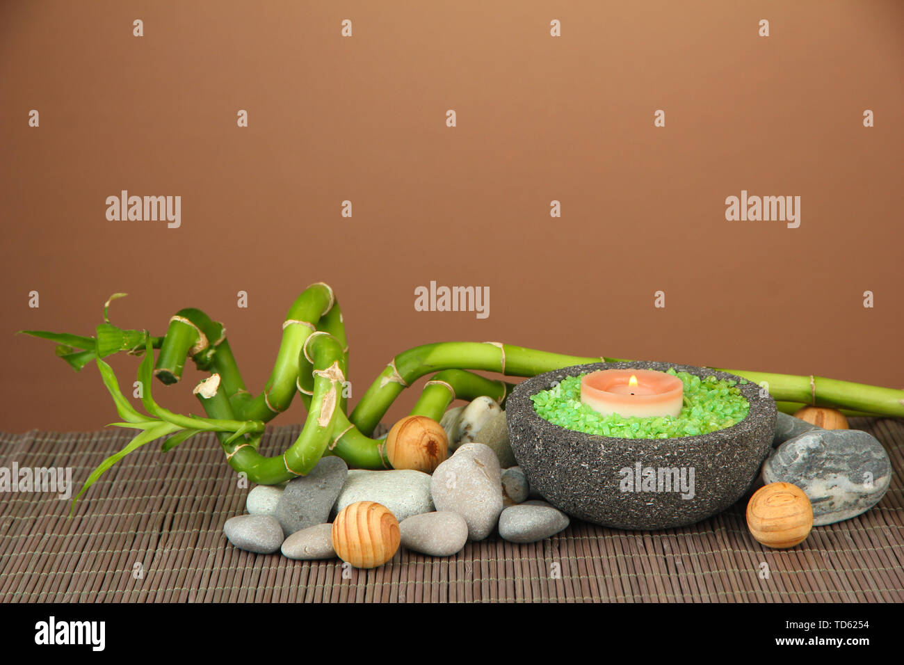 Still life with green bamboo plant and stones, on bamboo mat on color ...