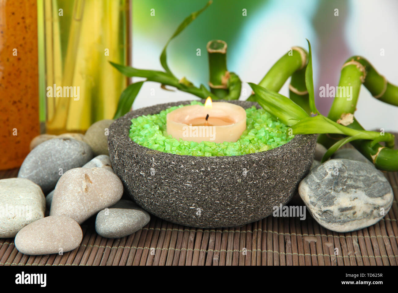 Still life with green bamboo plant and stones, on bamboo mat, on bright ...