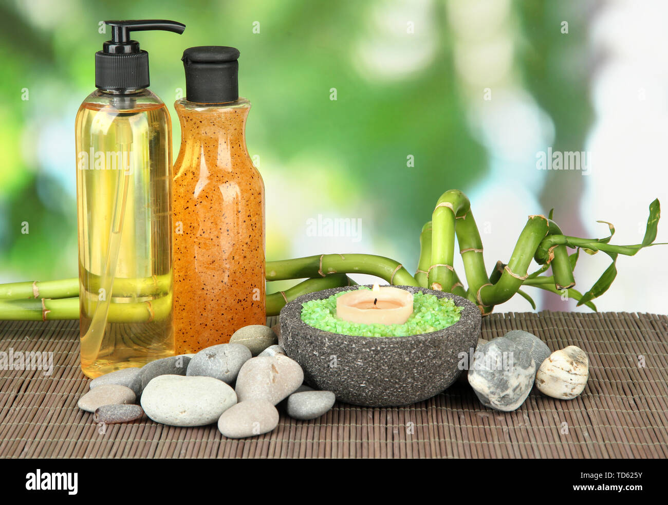 Still life with green bamboo plant and stones, on bamboo mat, on bright ...