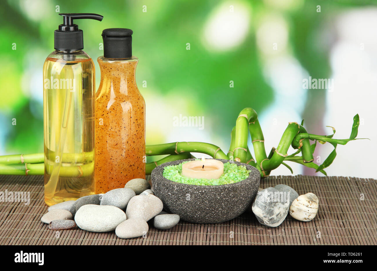 Still life with green bamboo plant and stones, on bamboo mat, on bright ...