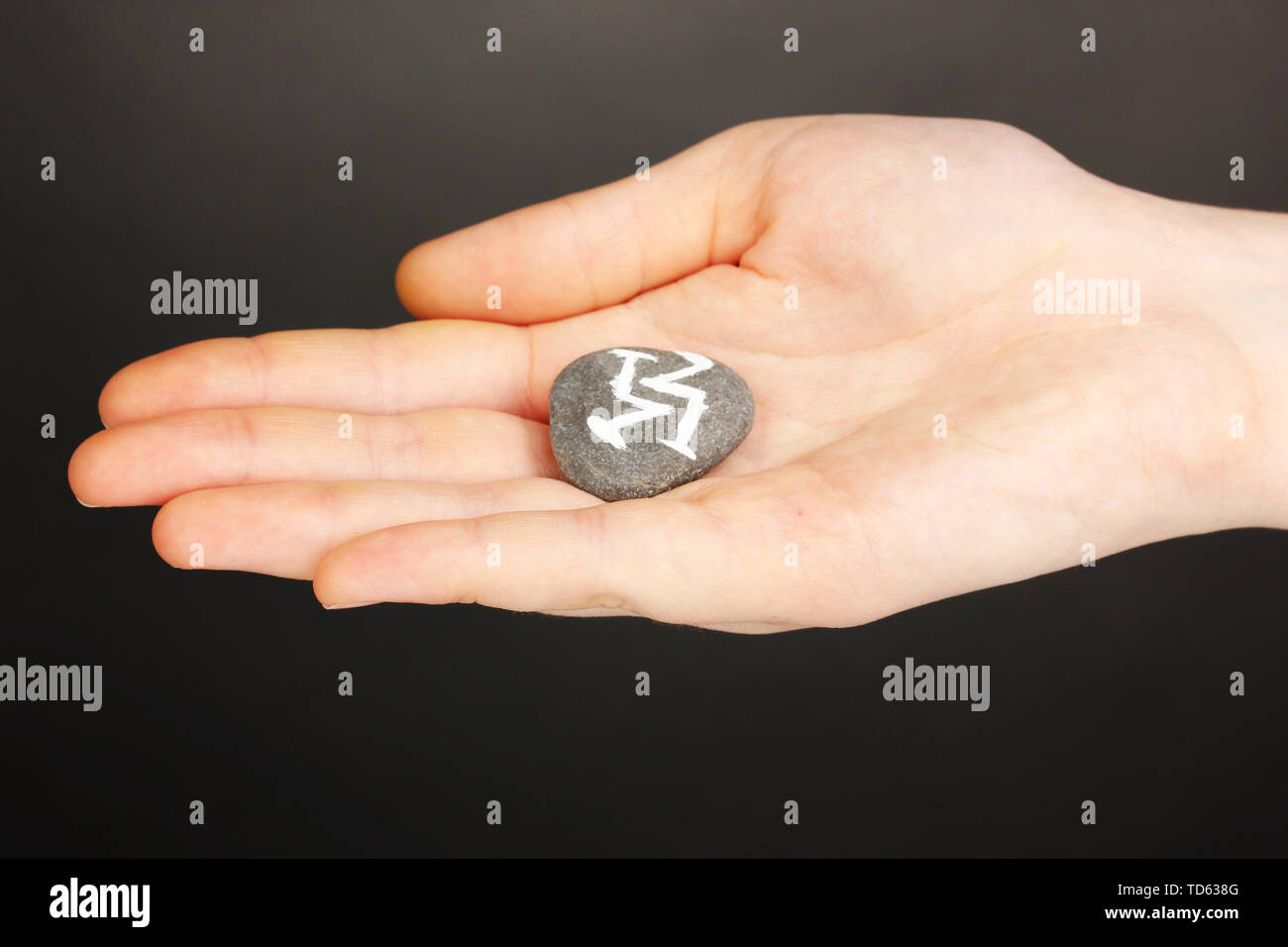 Fortune telling with symbols on stone in hand on grey background Stock ...
