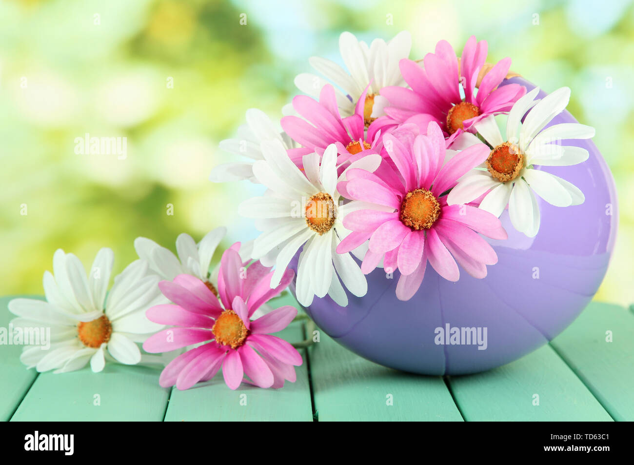 Pot with flowers on a wooden table on the nature background Stock Photo ...