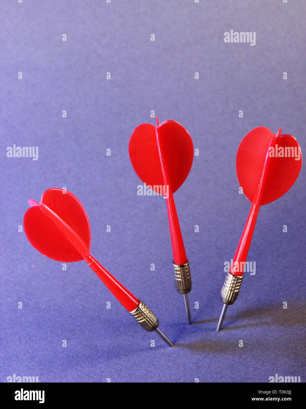 Darts on purple background Stock Photo - Alamy