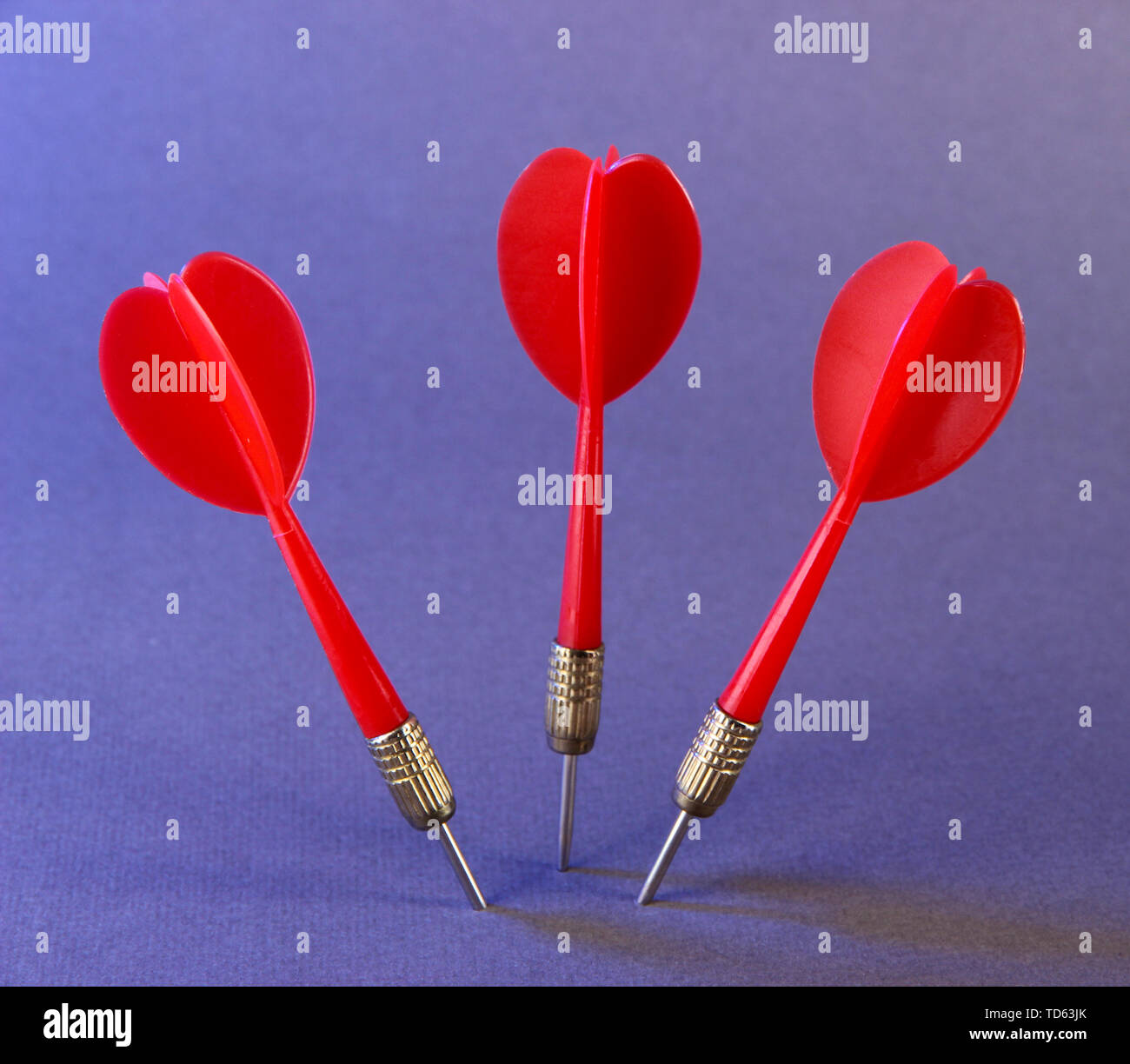 Darts on purple background Stock Photo - Alamy
