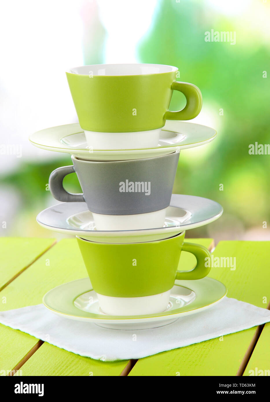 Three cups on nature background Stock Photo - Alamy