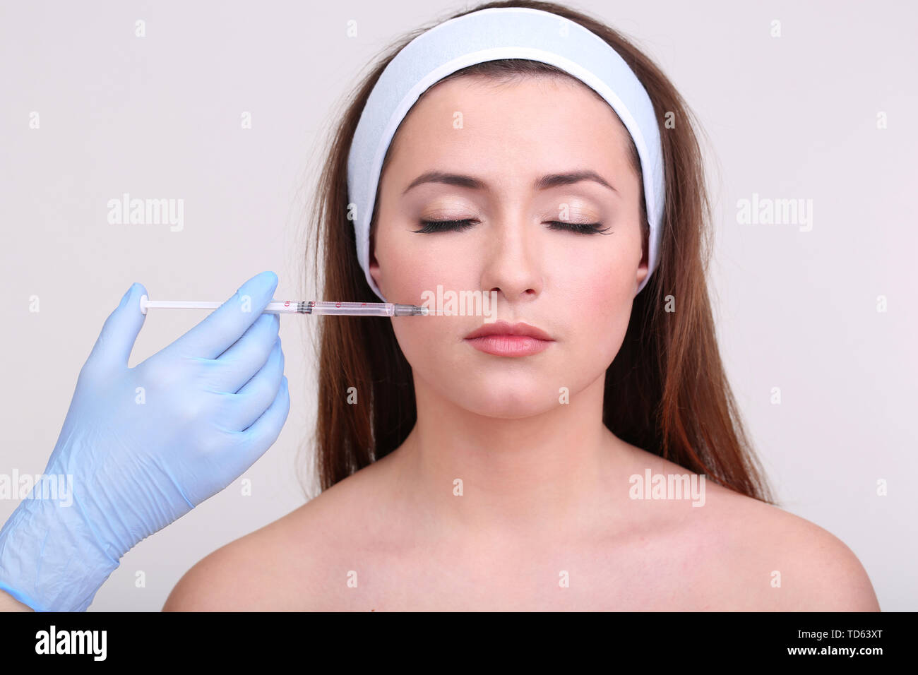 Young woman receiving plastic surgery injection on her face close up ...