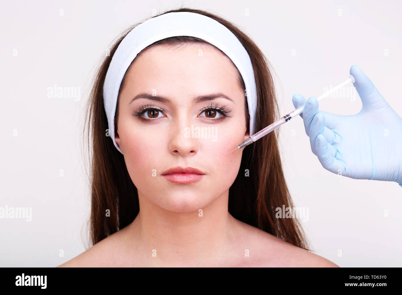 Young woman receiving plastic surgery injection on her face close up ...