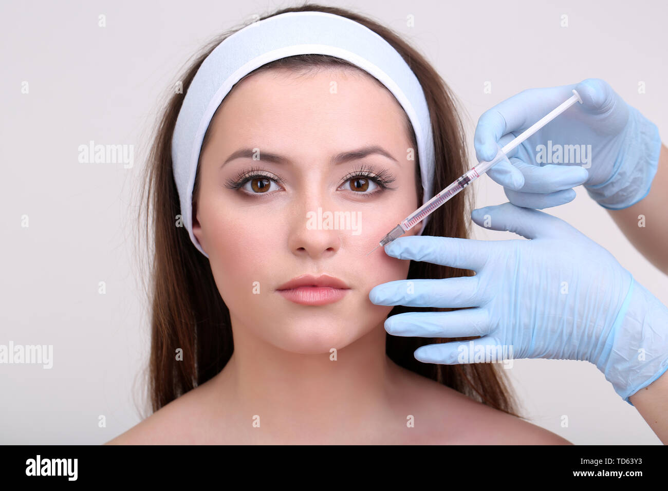 Young woman receiving plastic surgery injection on her face close up ...